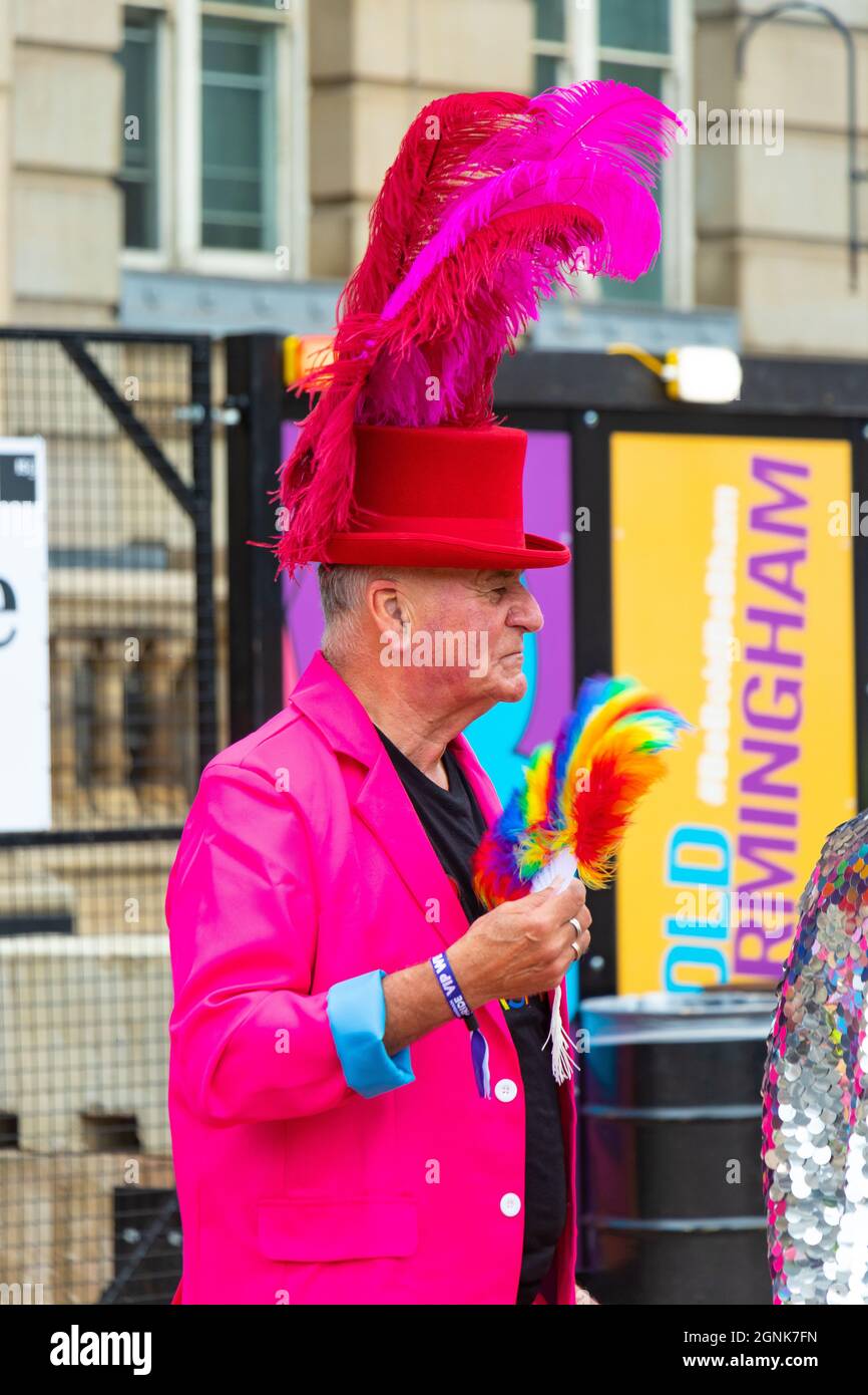 older man wearing pink suit and feather boa makes phone call at ...