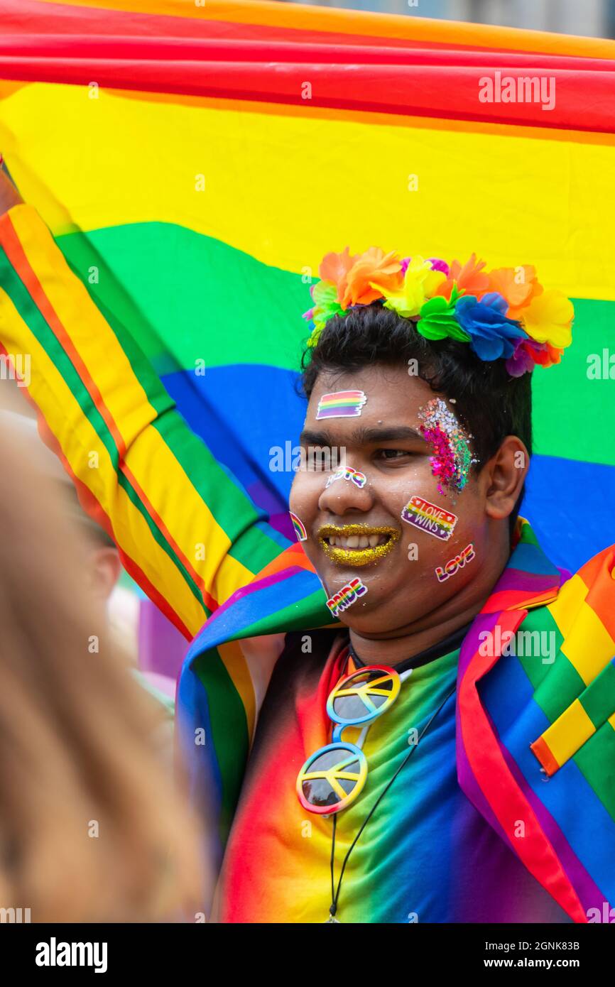 young Asian asian man poses with rainbow flag at Birmingham Pride ...