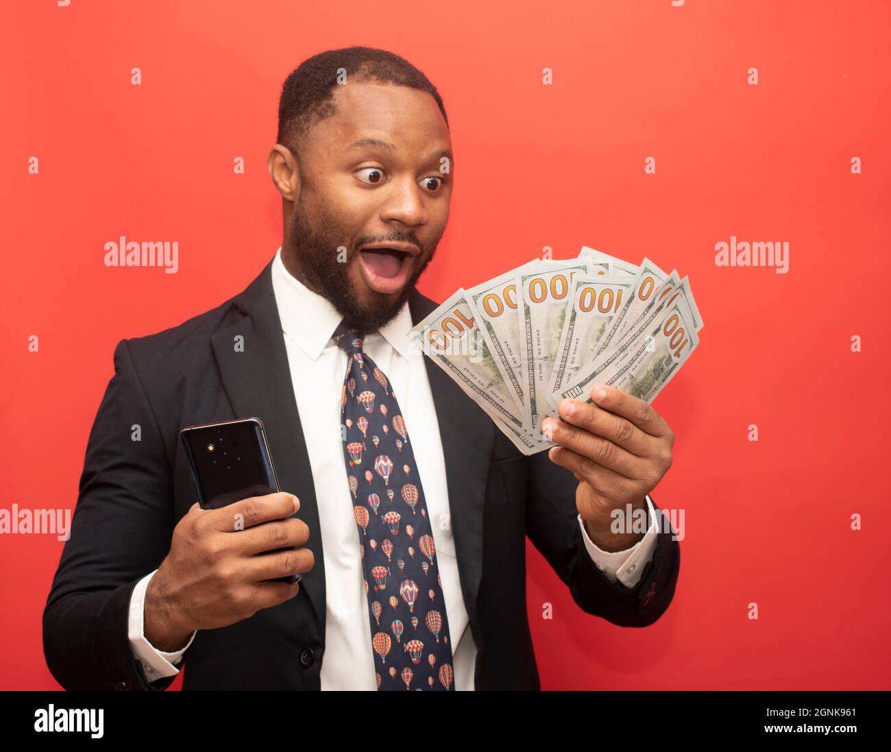 a surprised man after winning some dollars Stock Photo - Alamy