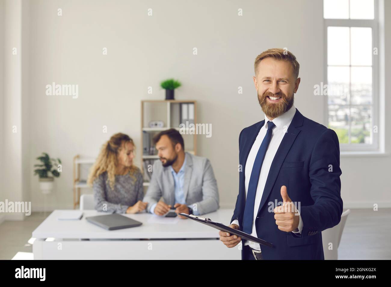 Happy real estate agent or mortgage broker standing in office, smiling ...