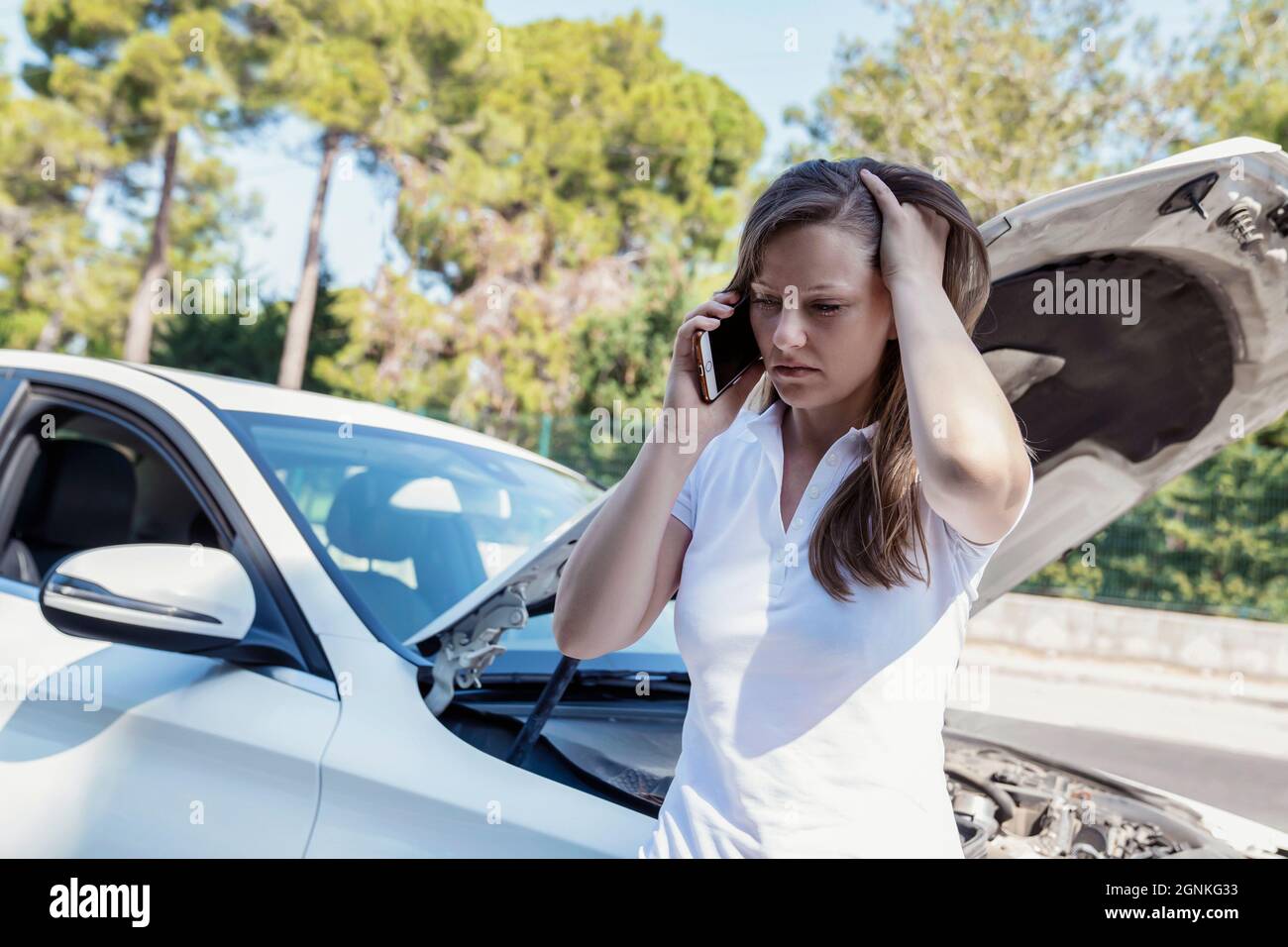 Car breakdown. A worried female driver is trying to call for auto ...