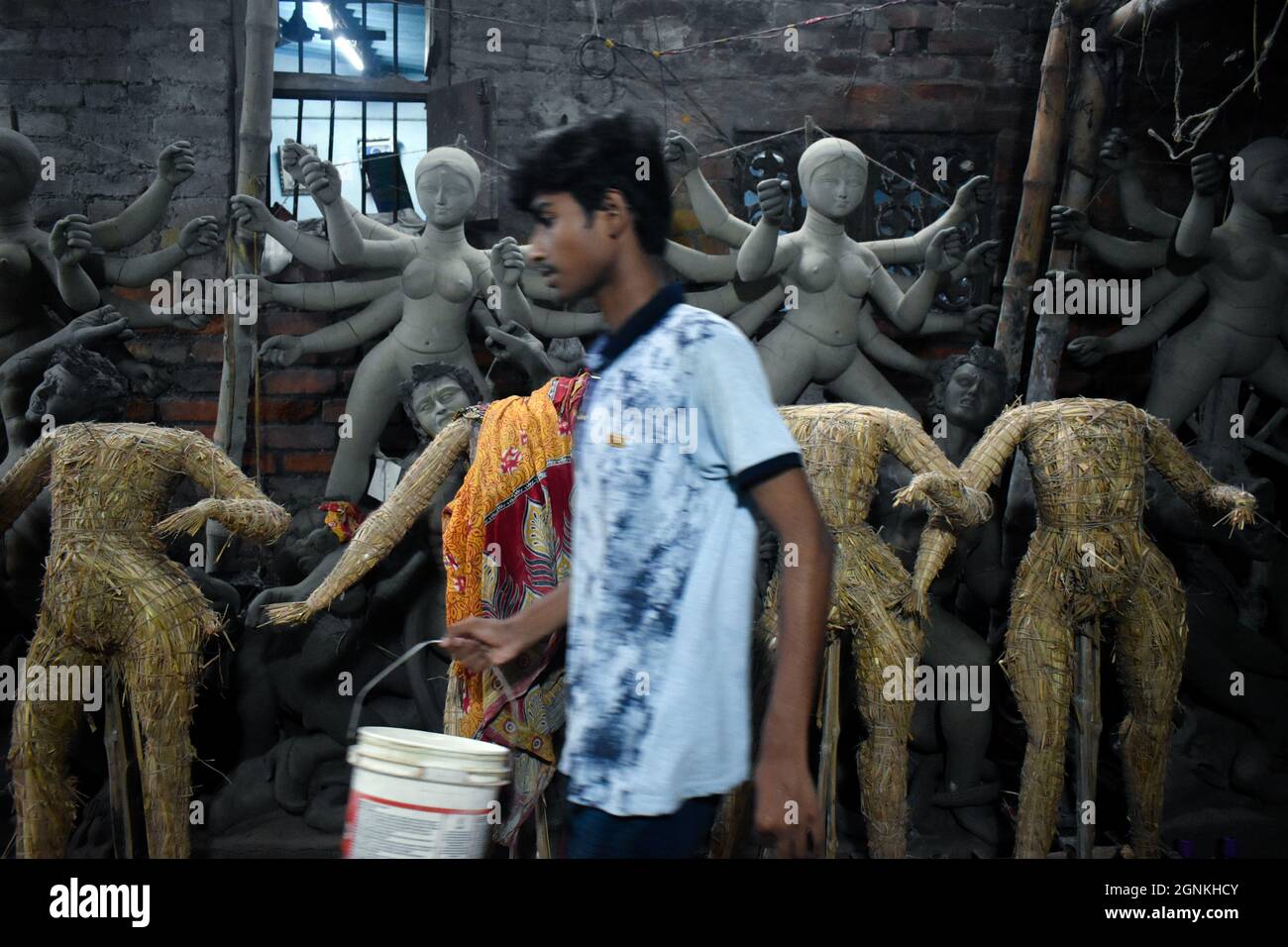 An idol maker is working inside a pottery hub during heavy rainy ...