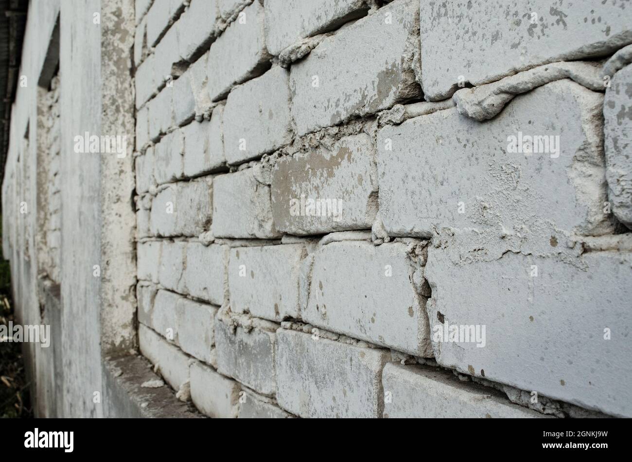 White painted old brick wall, perspective view from right-hand side ...
