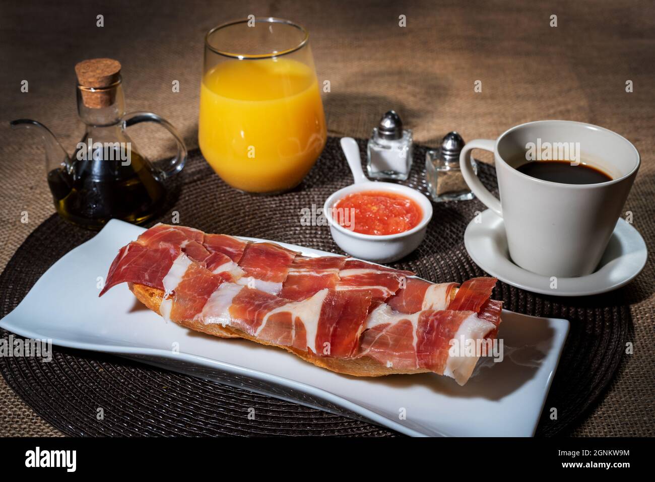 Breakfast consisting of coffee, juice, and ham toast with tomato and ...