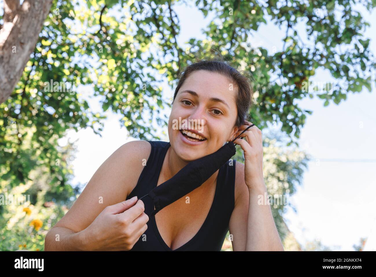 Happy positive girl takes off protective medical mask from face ...