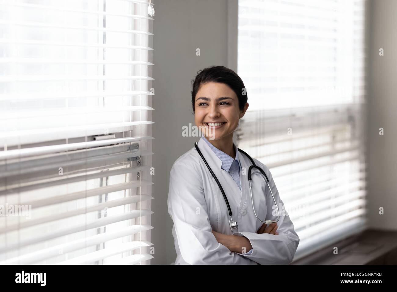 Confident female Indian doctor standing by window Stock Photo - Alamy