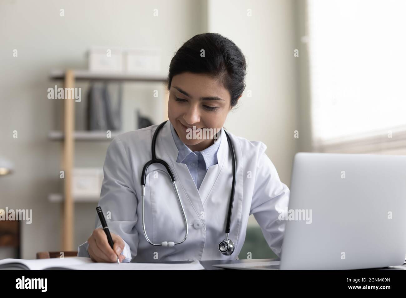 Smiling friendly GP doctor giving online distance video consultation ...