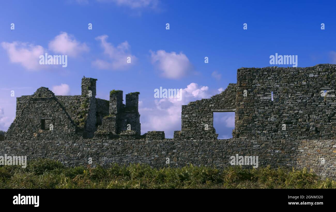 The ruins of the Dunluce Castle under a blue cloudy sky in Northern ...