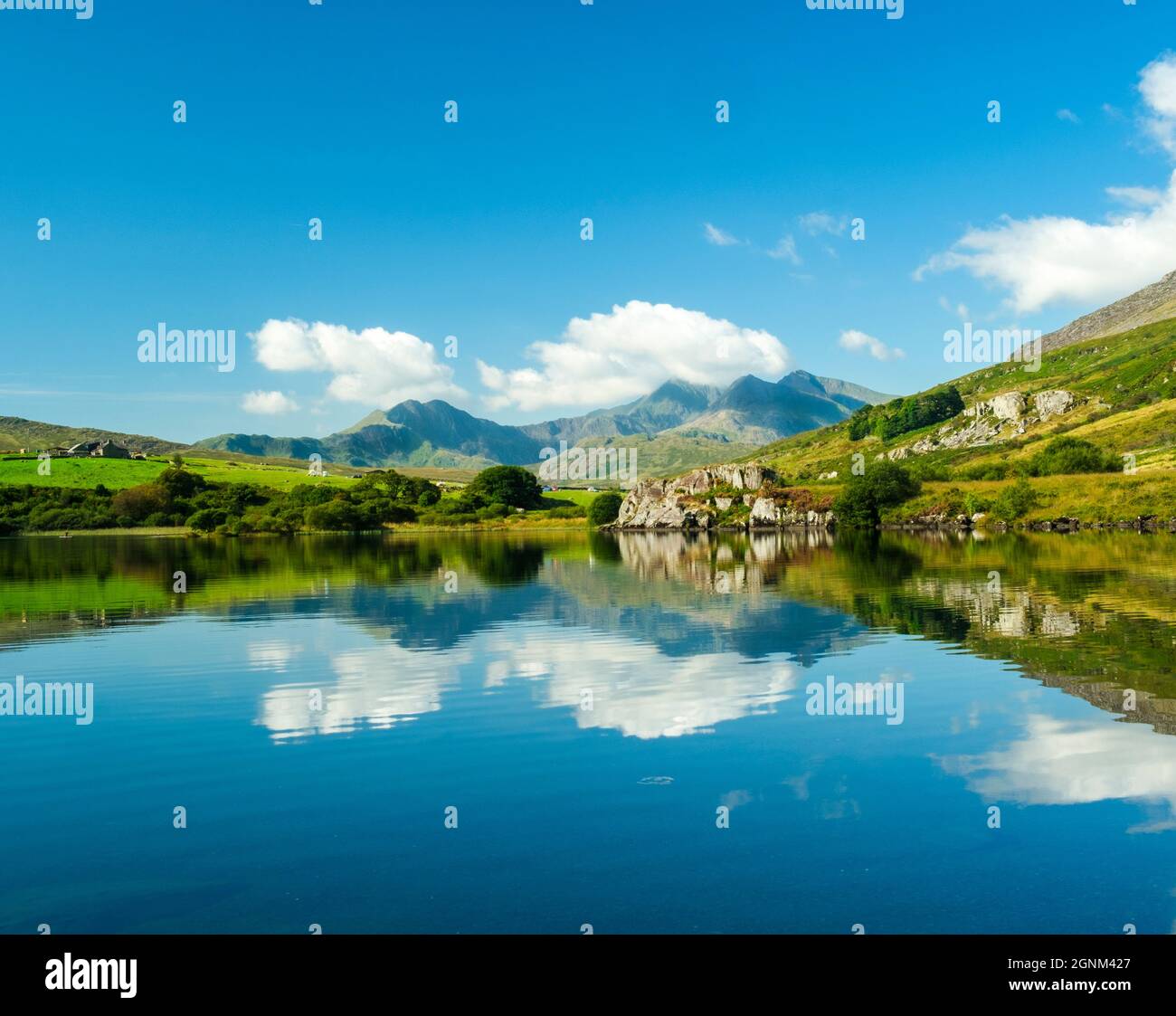 The Snowdon mountains reflected in a lake in the Snowdonia National ...