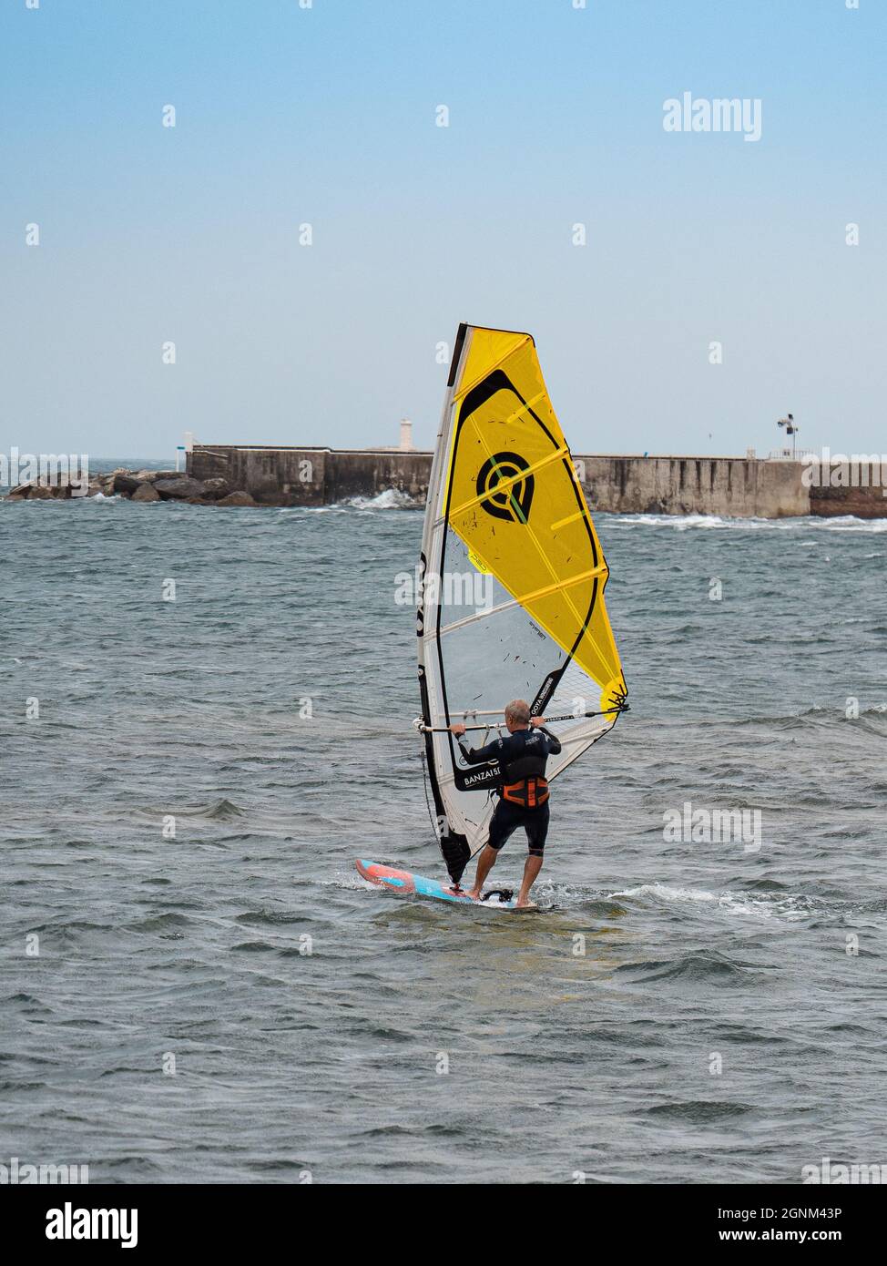 Yellow windsurf Riding the Waves in a Choppy Sea Stock Photo - Alamy