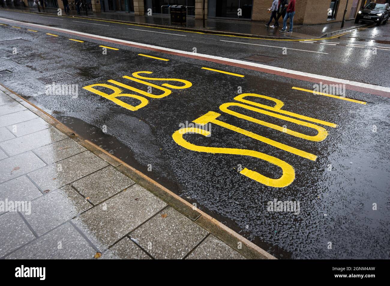 Yellow bus stop signage printed on street road Stock Photo - Alamy