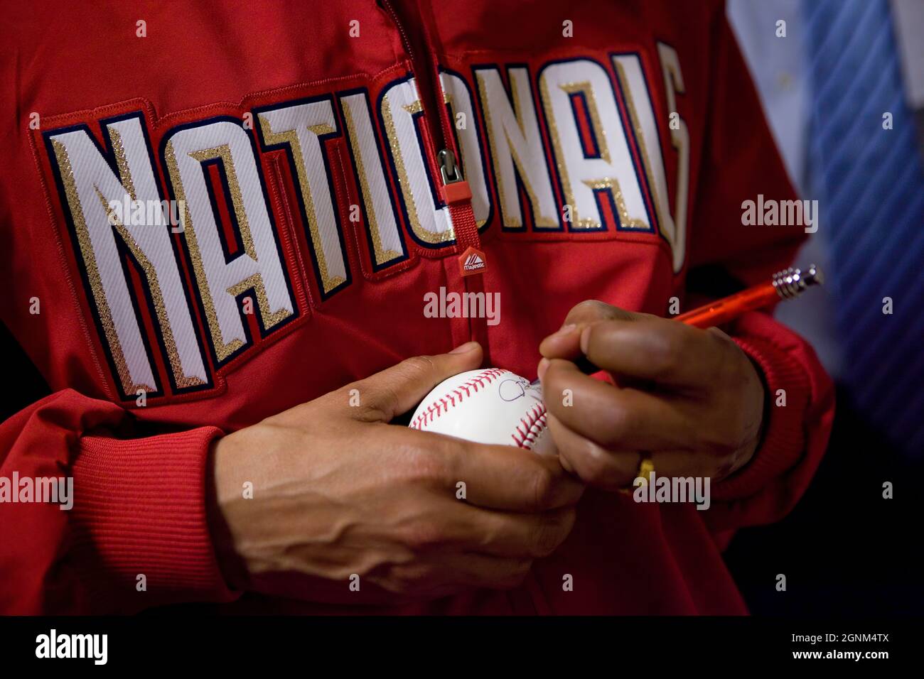 President Barack Obama signs a baseball after throwing out the ...