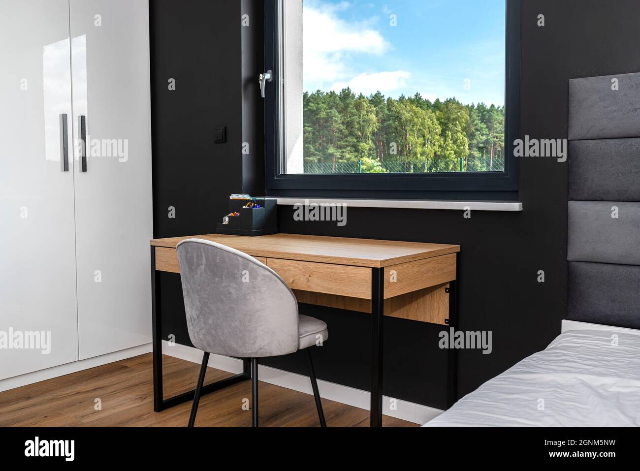 A wooden table with chair under the window in a modern boy room in ...