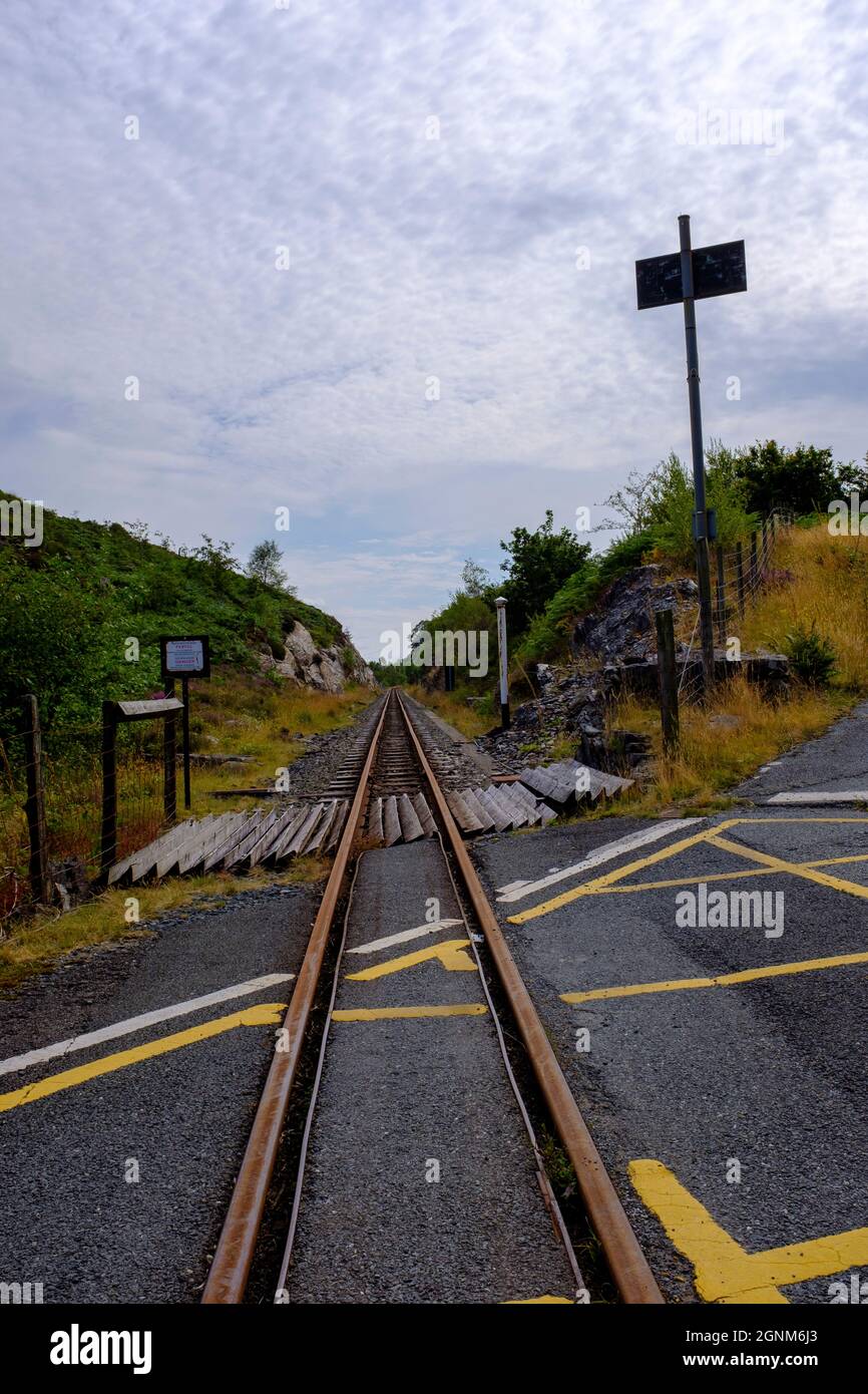 Single line rail tracks heading into the distance Stock Photo - Alamy