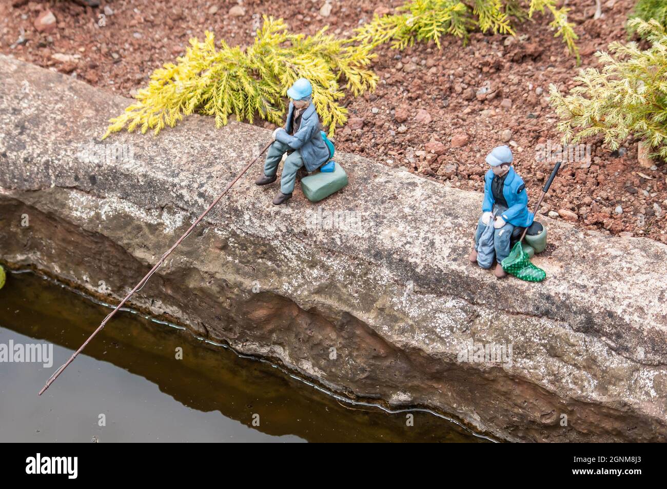Closeup of tiny model men fishing in a lake Stock Photo - Alamy