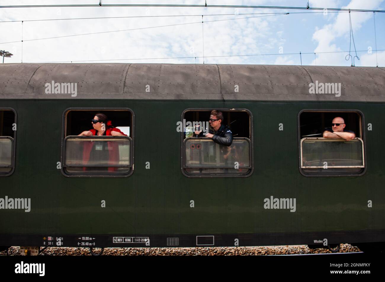 Passengers are seen looking out of the windows from the steam train ...