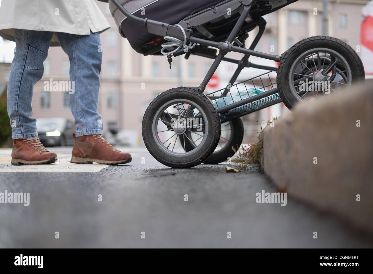 Mother pushing baby pram at a pedestrian crossing Stock Photo - Alamy