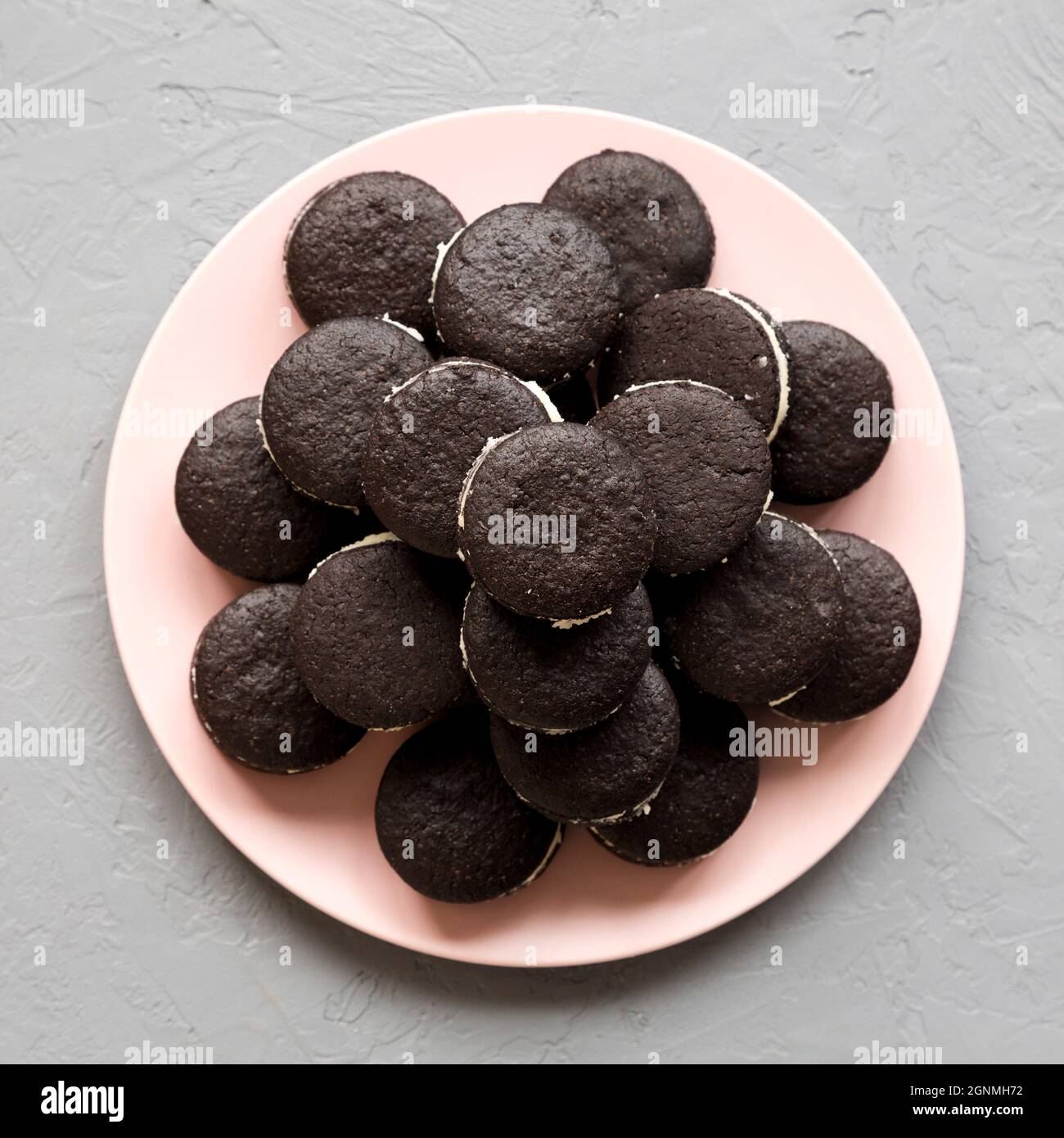 Homemade Oreos on a pink plate on a gray surface, top view. Flat lay ...