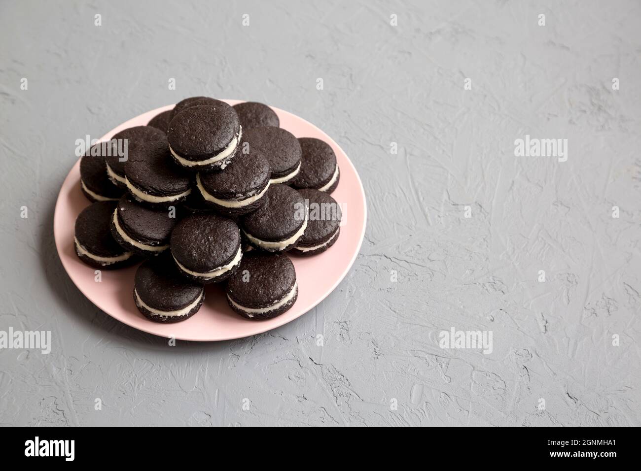 Homemade Oreos on a pink plate on a gray background, low angle view ...