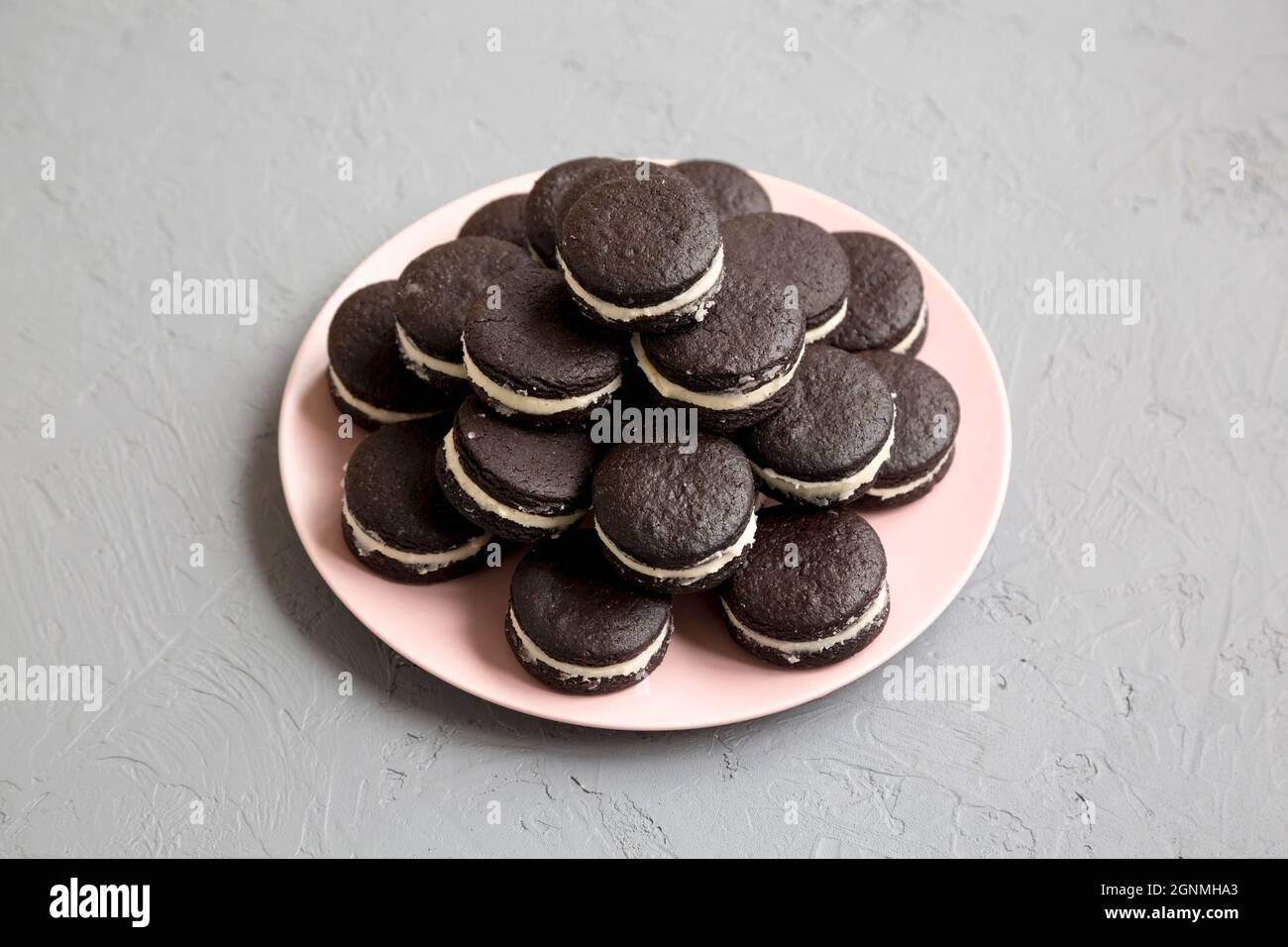 Homemade Oreos on a pink plate on a gray surface, low angle view Stock ...