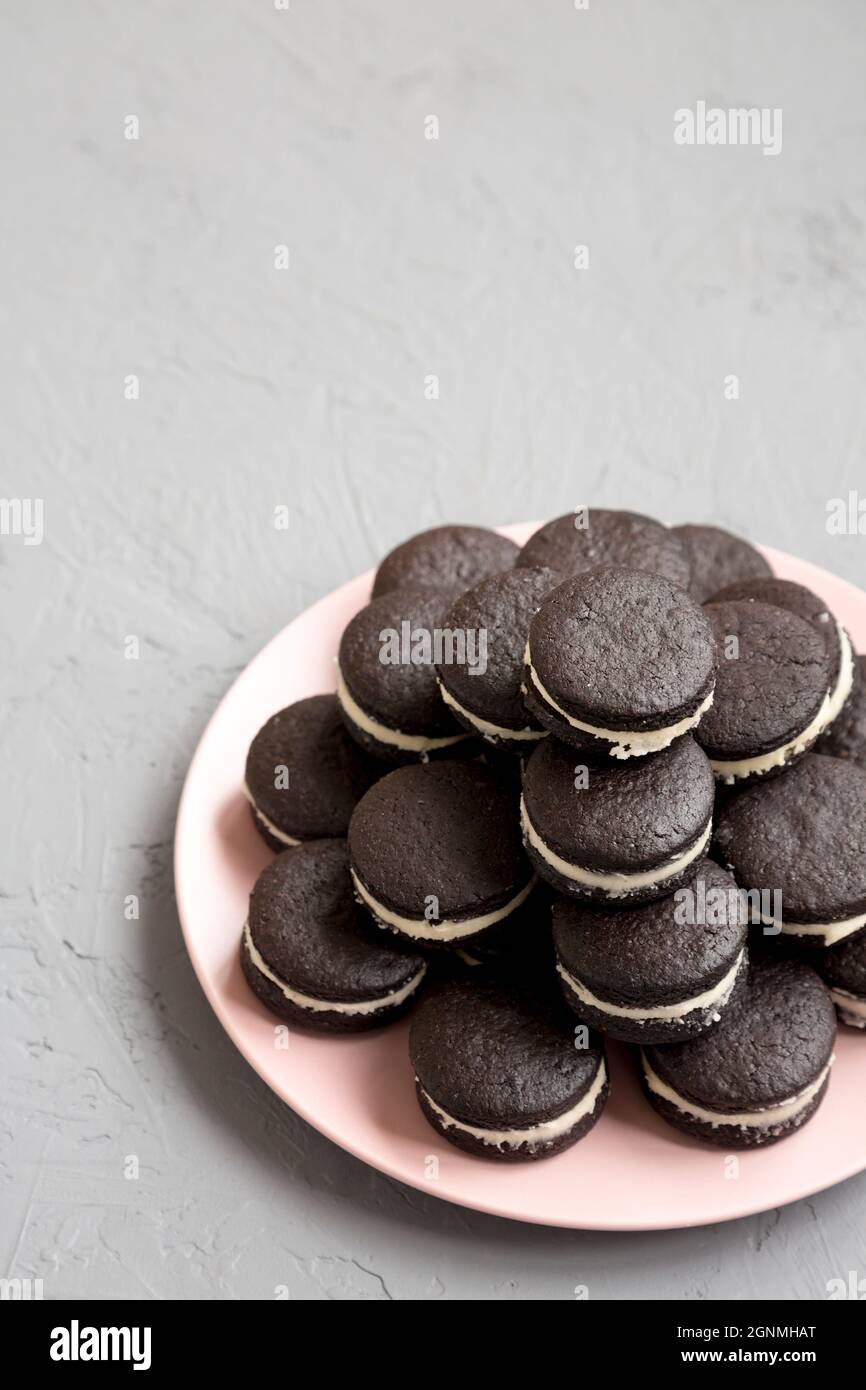 Homemade Oreos on a pink plate on a gray background, side view. Space ...