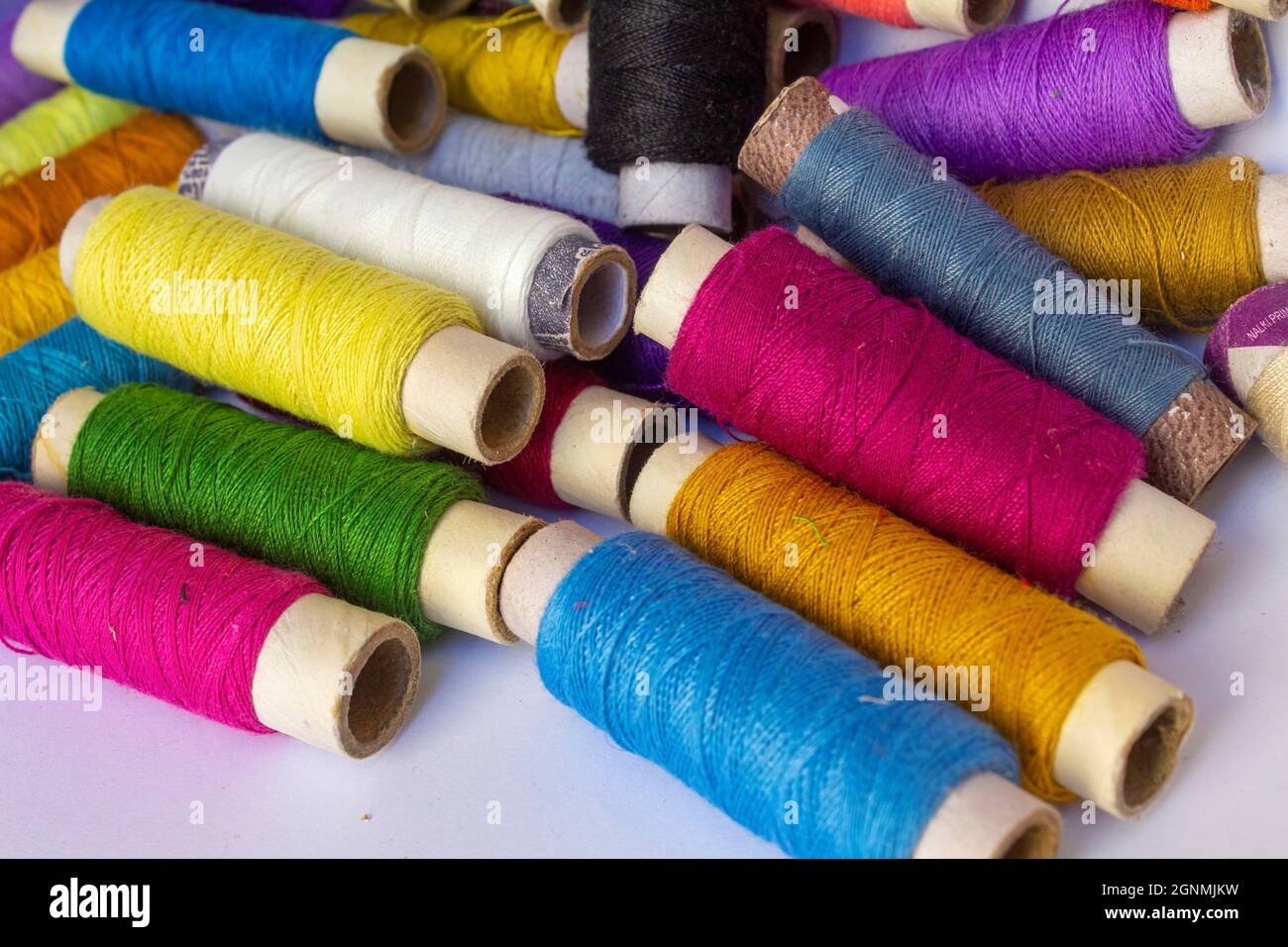 multicolour sewing thread bobbin on white background Stock Photo - Alamy