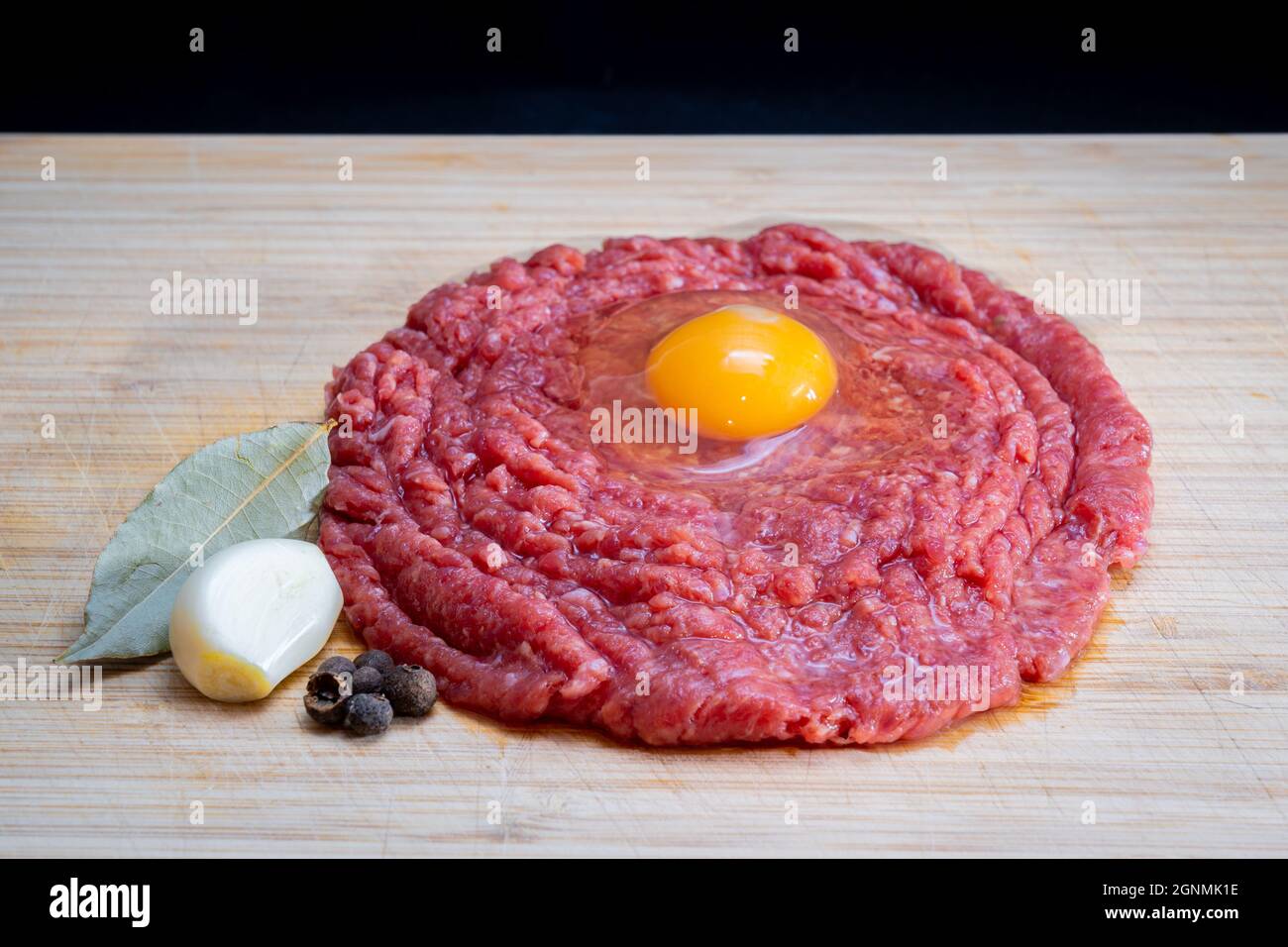 Beef tartar in wood with raw egg on top Stock Photo - Alamy