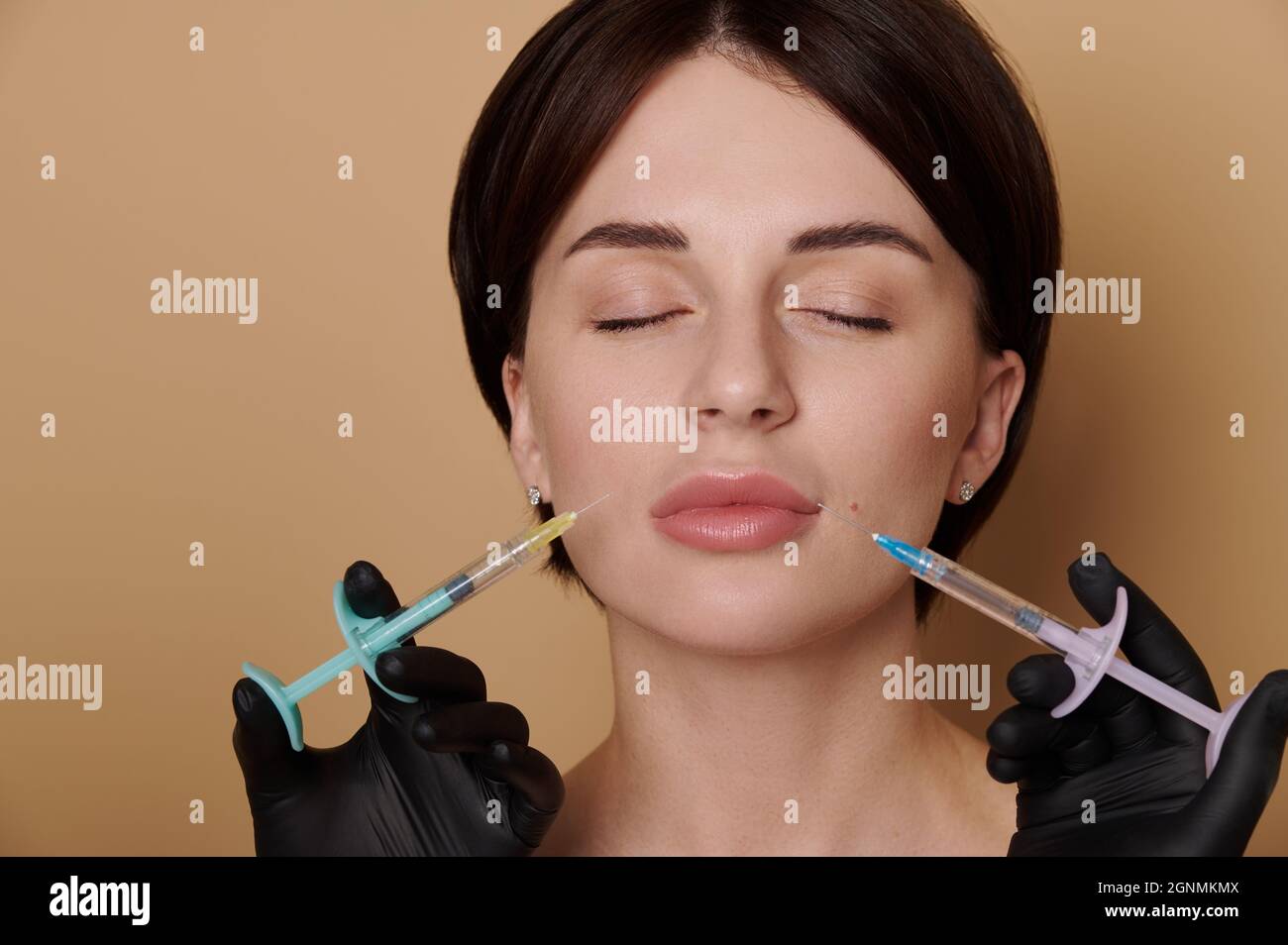 Headshot of beautiful young woman receiving beauty injections on her ...