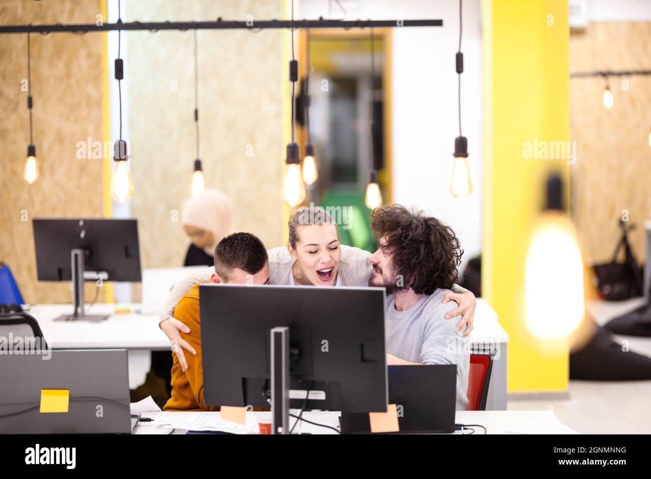 Three caucasian colleagues cheering for job well done in a modern ...