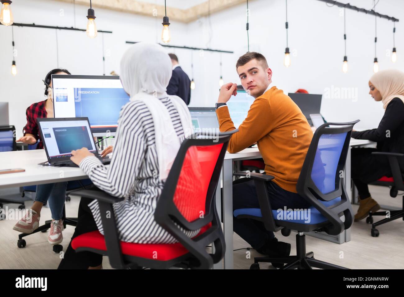 Group of multiethnic colleagues working on desktop computers in a ...