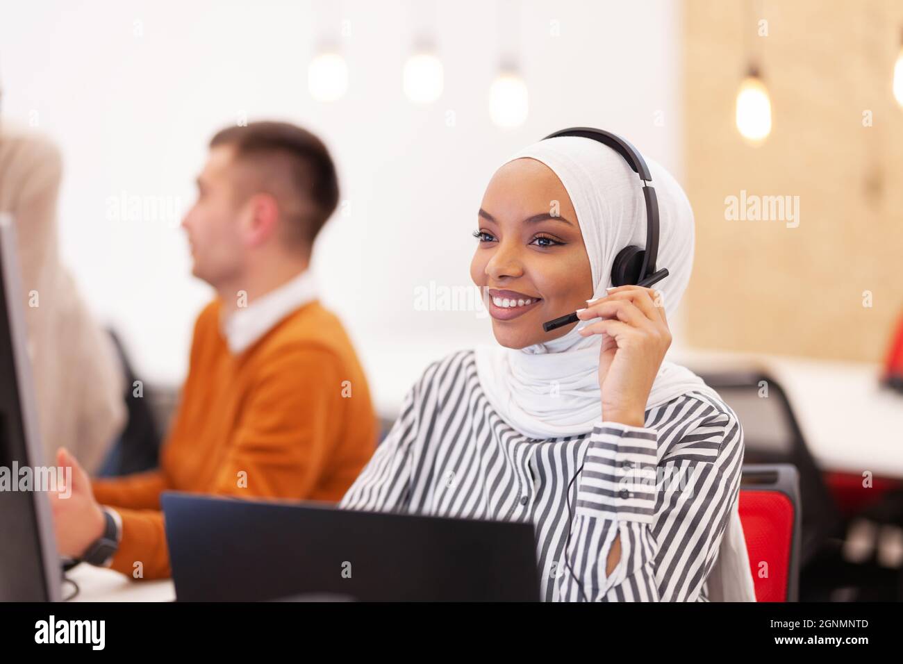 African american muslim girl with hijab and headset in a modern office ...