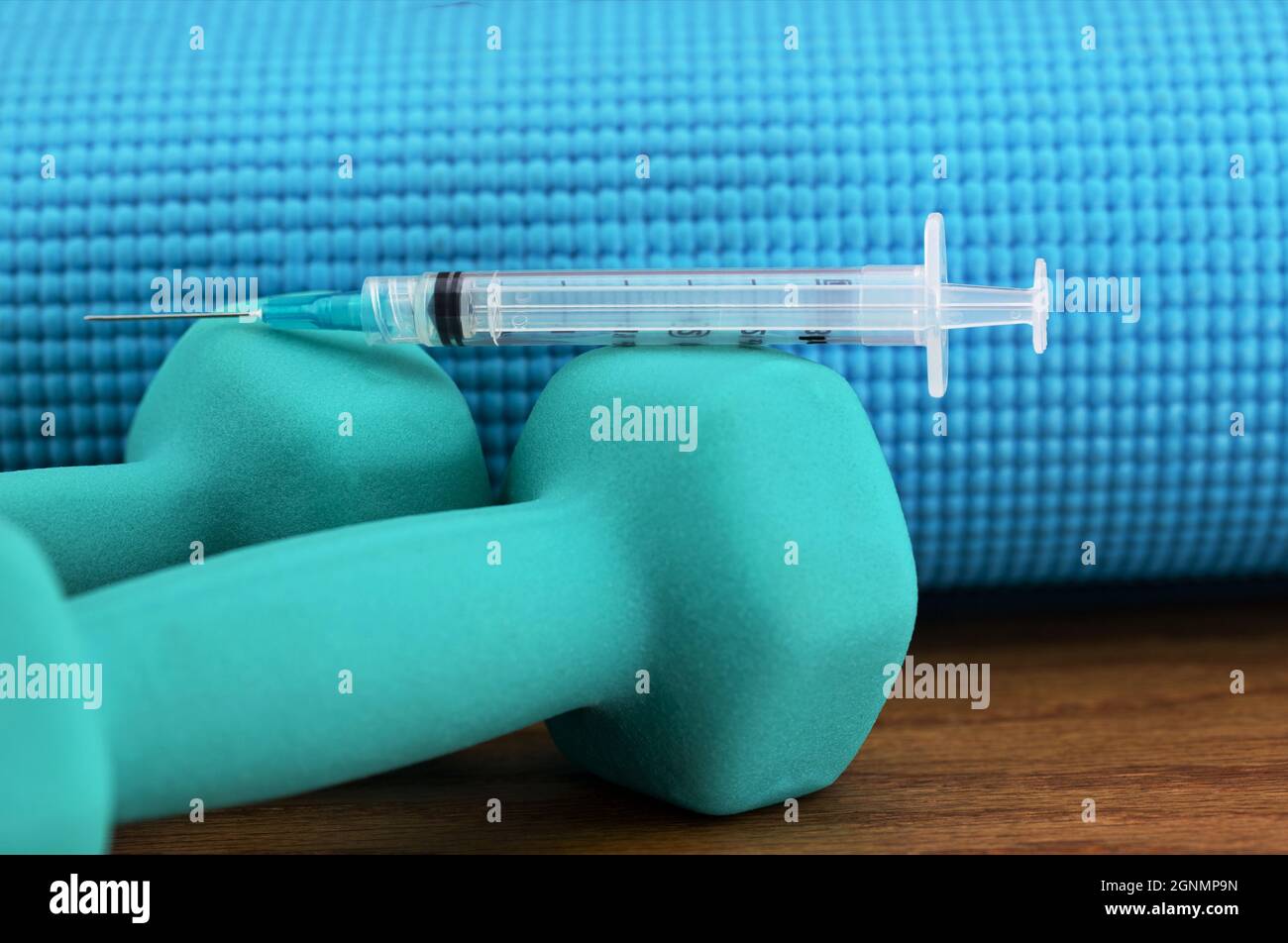 Injection needle for vaccine placed with yoga mat and light weights ...