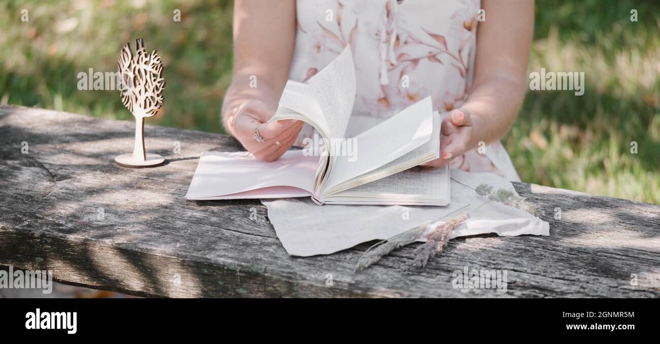 Woman writing, reading diary on the wooden table. Romantic memories ...