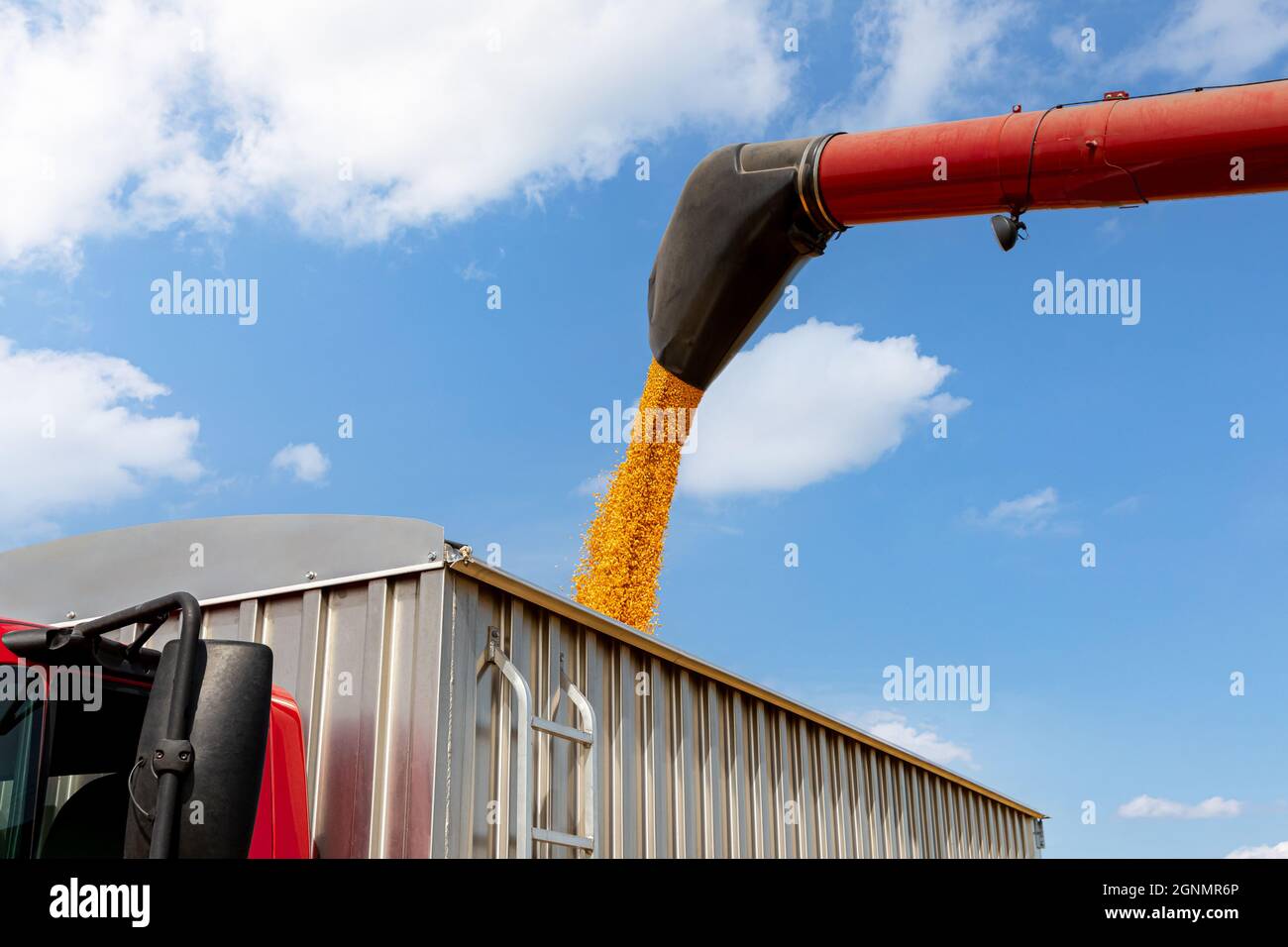 Combine harvester loading corn kernels into grain truck during harvest ... Combine harvester loading corn kernels into grain truck during harvest ...