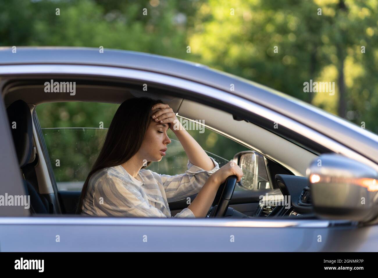 Stressed girl with headache drive car. Frustrated displeased young ...