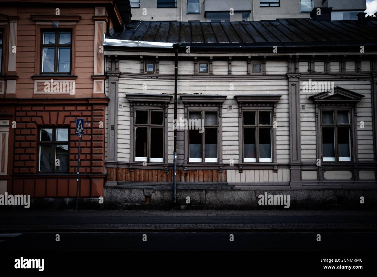 The architectural details of a traditional wooden house beside a brick ...
