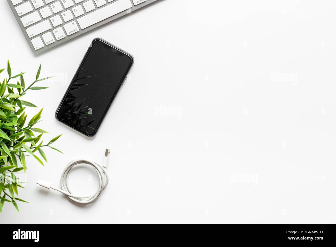 Cables for charging smartphone or laptop on office table, top view ...