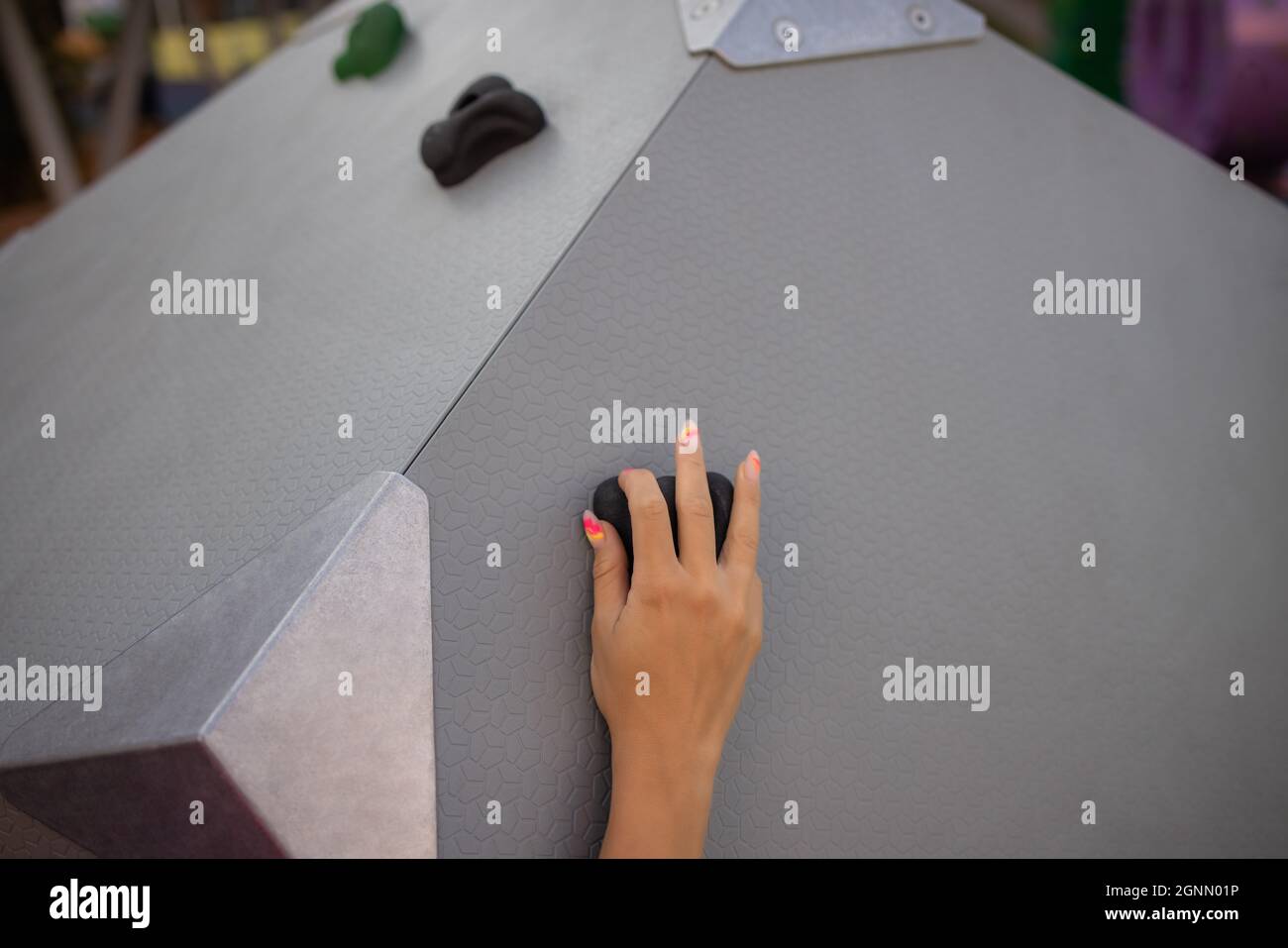 Yellow climbing wall with colorful rocks playground Stock Photo - Alamy