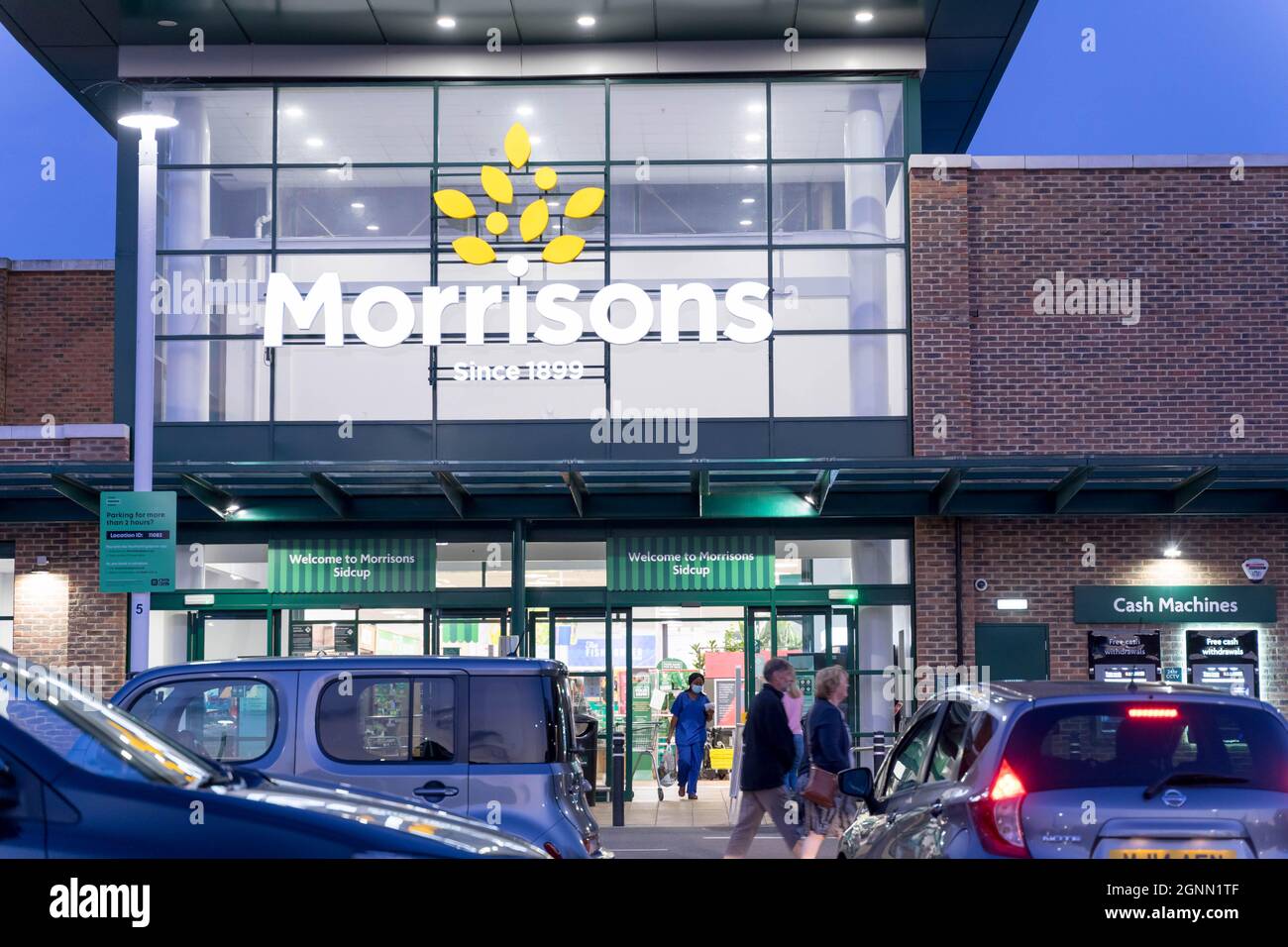 evening Shoppers outside entrance to Morrisons, walking towards their ...