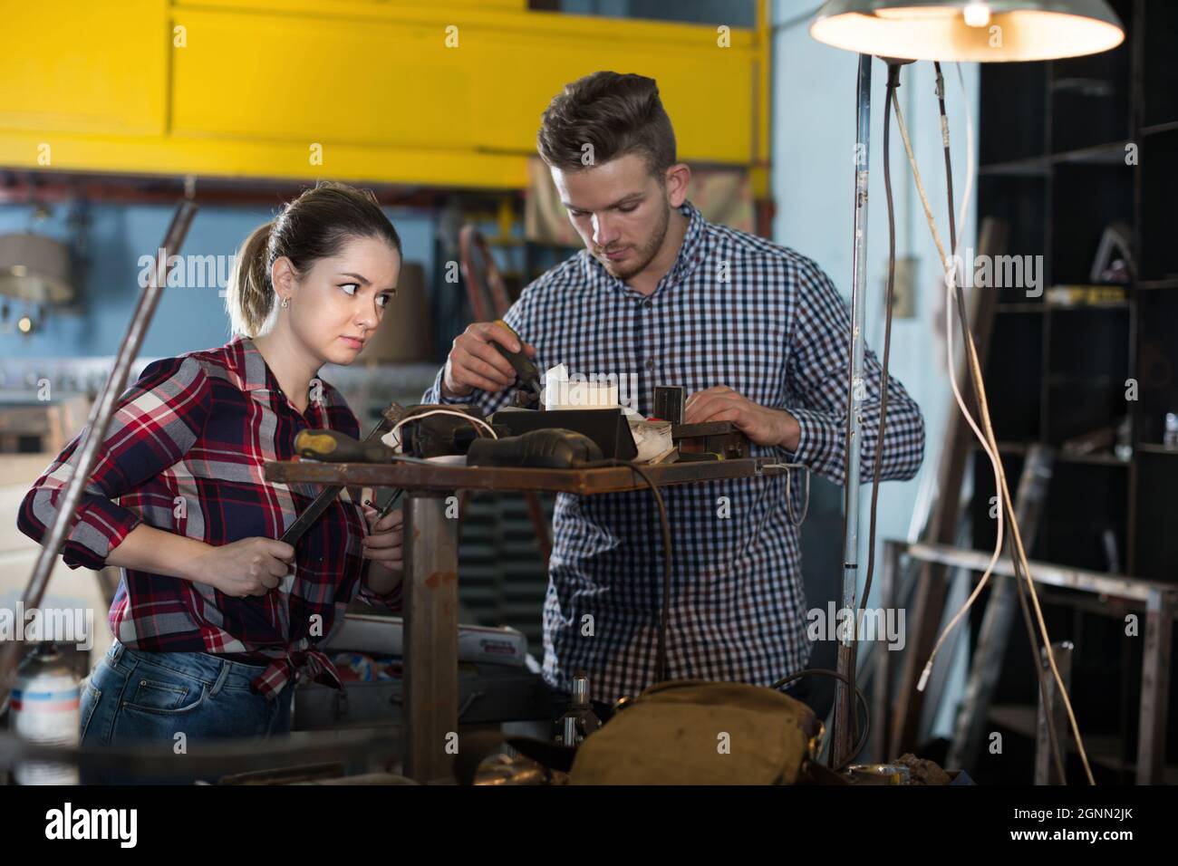 Man and woman working together in workshop Stock Photo - Alamy