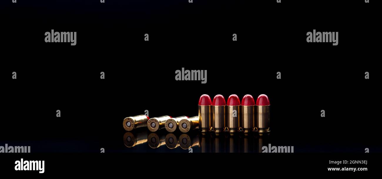 Pistol cartridges with red silicone coating. Bullets for a pistol on a ...