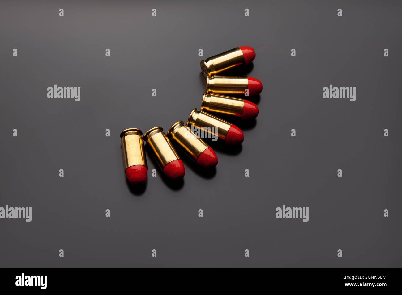 Pistol cartridges with red silicone coating. Bullets for a pistol on a ...