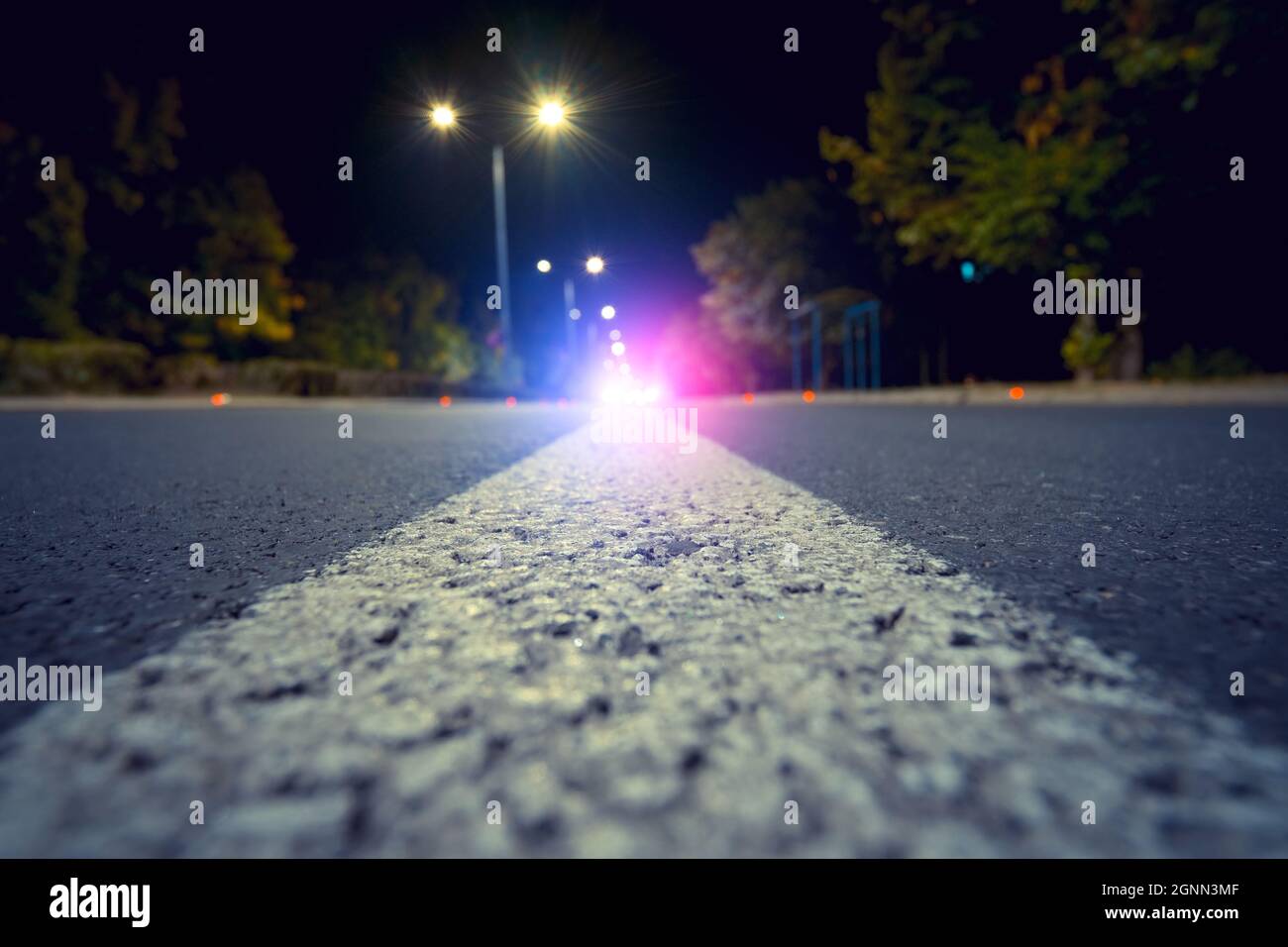 Focus on city road with blurred police car red and blue lights in the ...