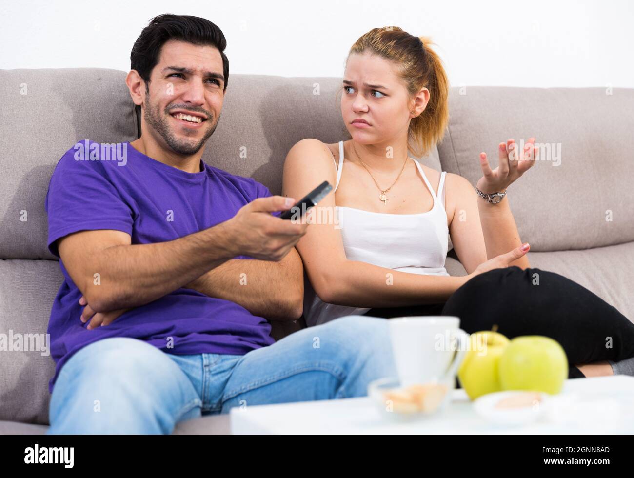 Couple arguing because of TV remote Stock Photo - Alamy