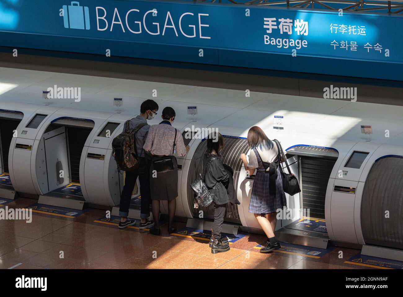 Passengers use the baggage Check-in and drop-off machine at Haneda ...