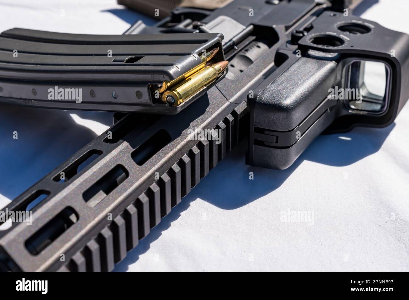 A rifle magazine loaded with 223 caliber bullets on top of a short ...