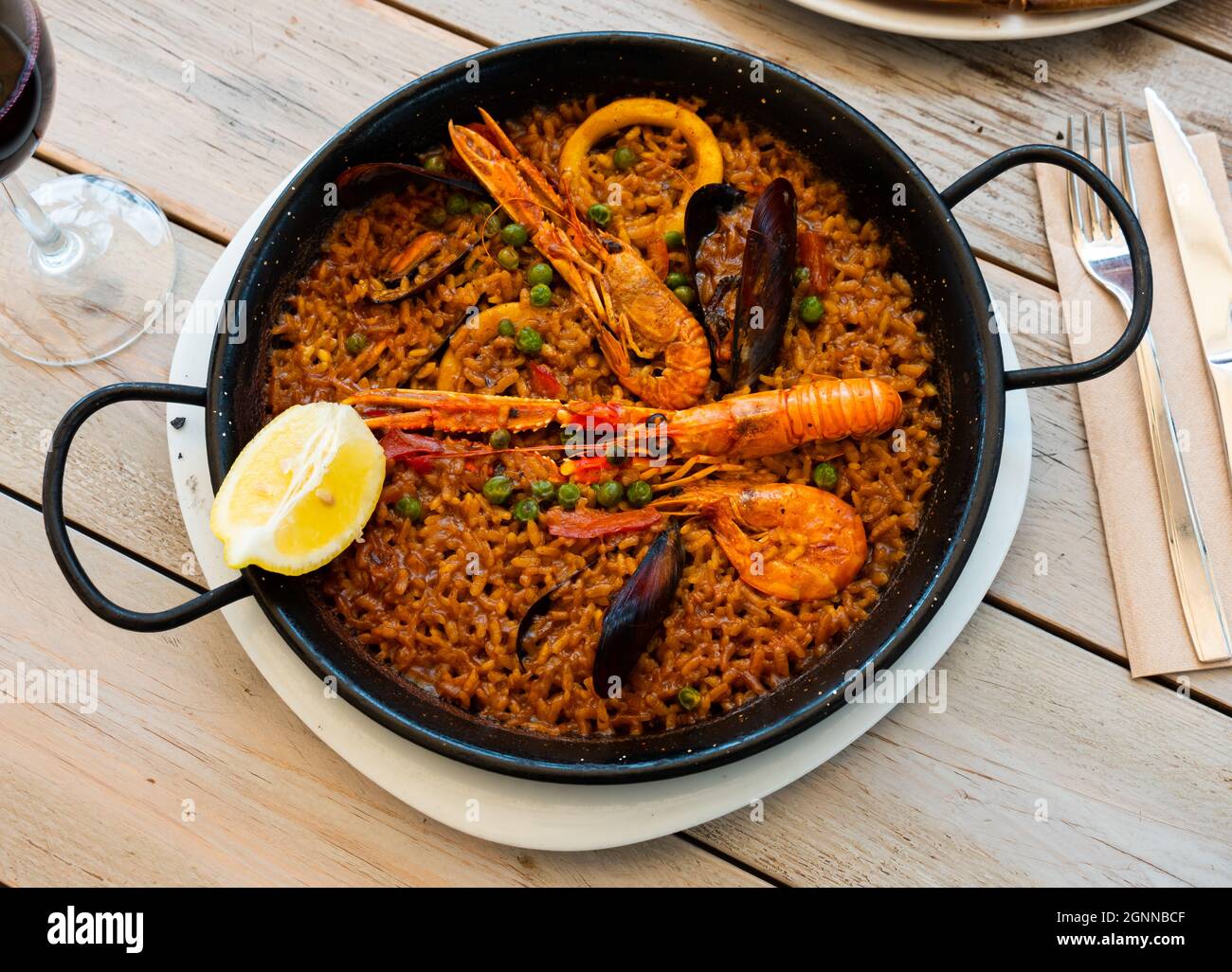 Traditional Valencian seafood paella with shrimps, squid and clams ...