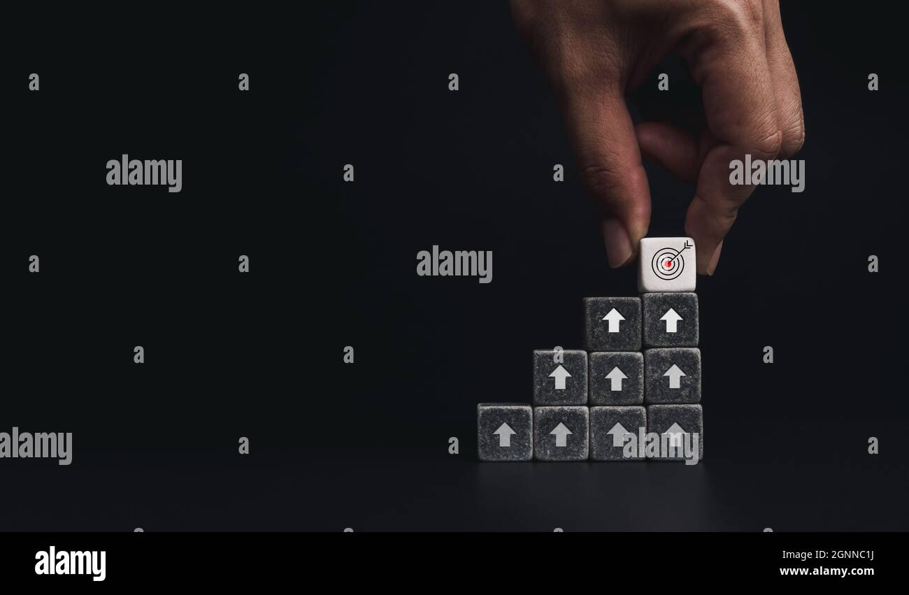 Hand putting the white dice blocks with target icon on the top of black ...