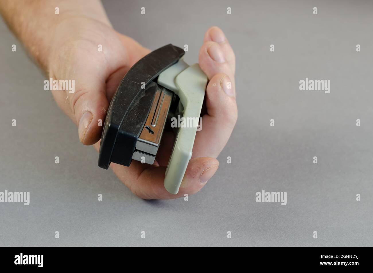Hand and stapler on gray background. A man holding a plastic pap Stock ...