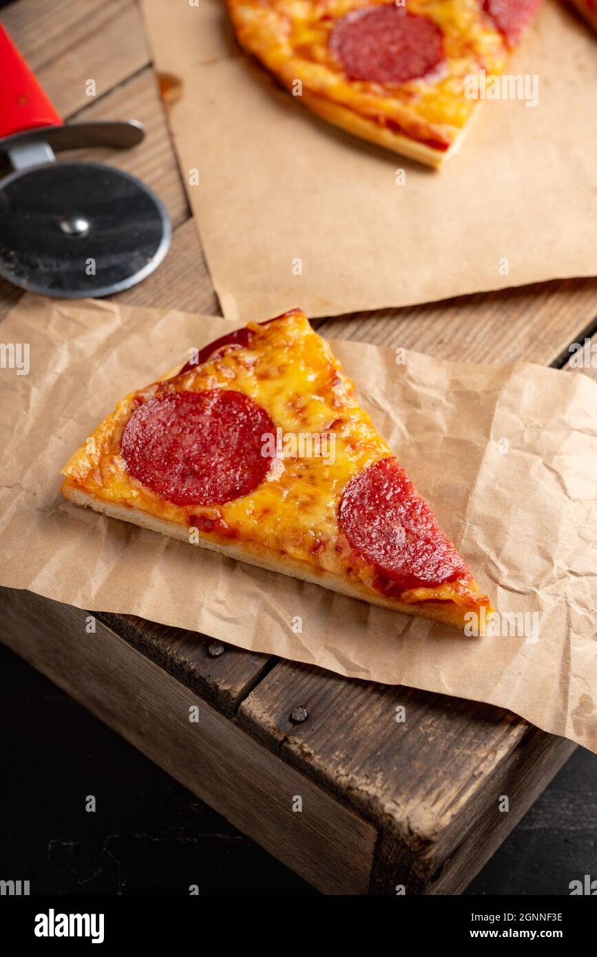 Fresh pepperoni pizza served on the wooden board. Selective focus ...